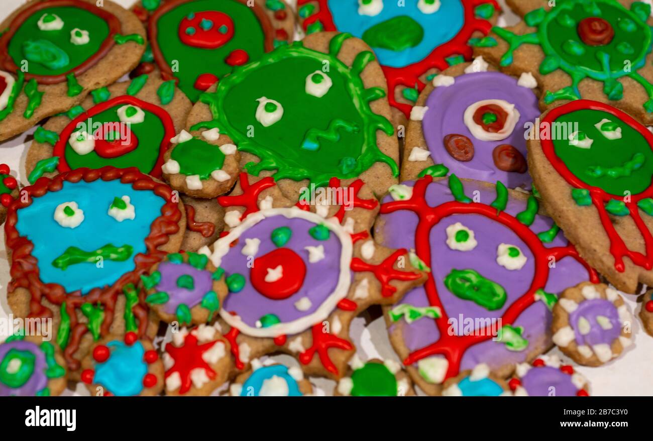 Cookies frosted with red, green, purple and blue, decorated like germs ...