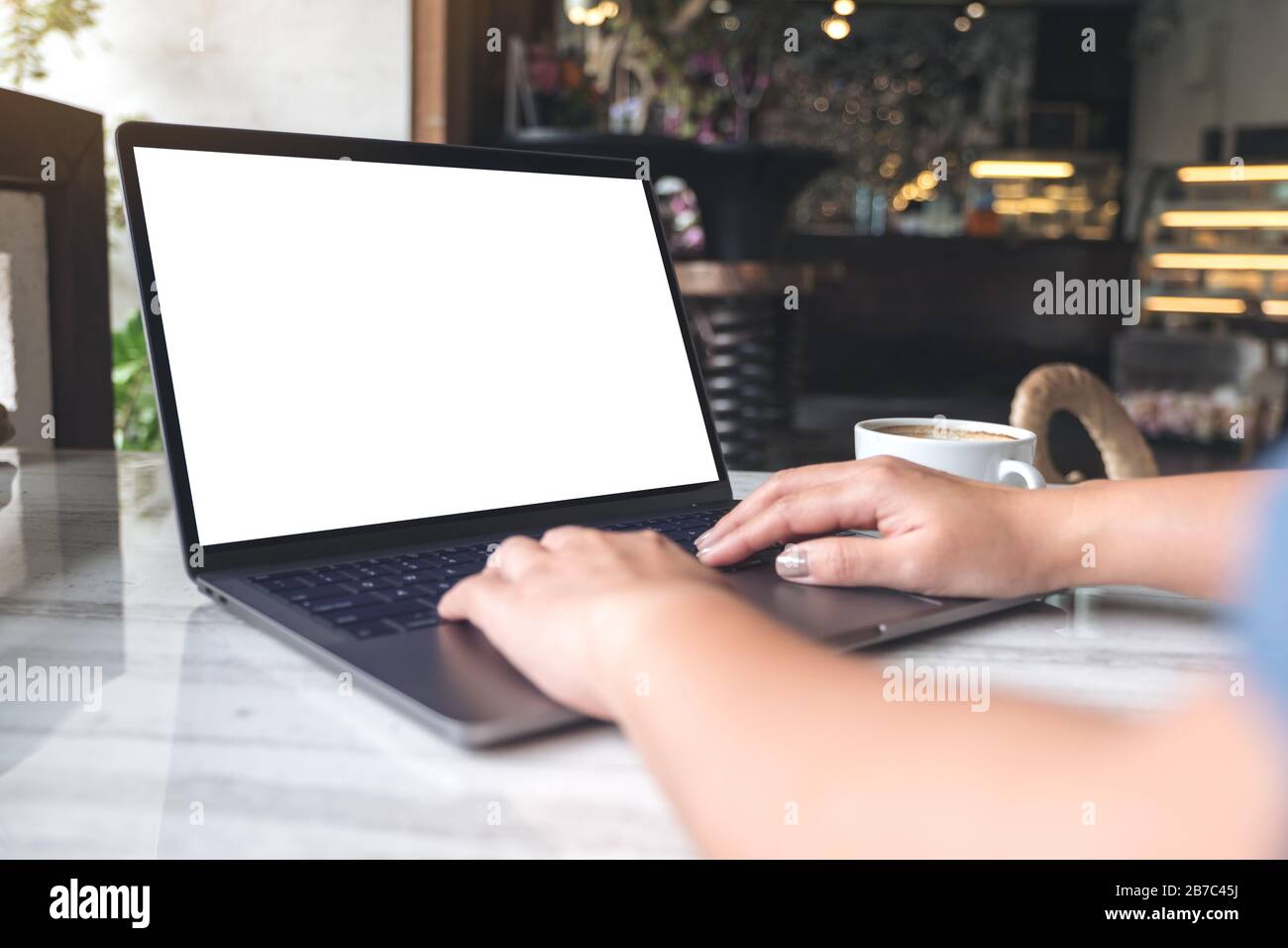 Mockup image of a woman using and typing on laptop with blank white ...