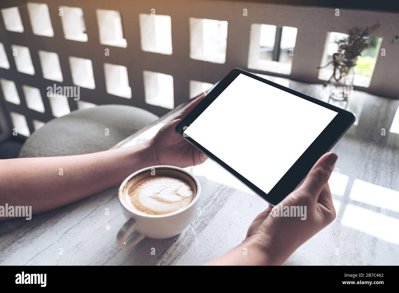 Mockup image of a woman holding black tablet pc with white blank screen ...