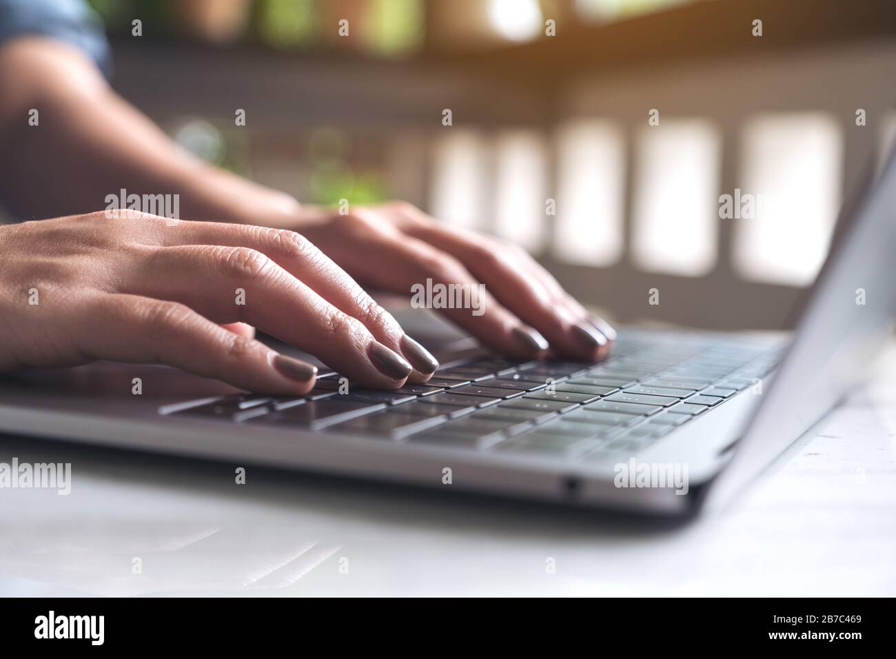Closeup image of a woman's hands working and typing on laptop keyboard ...