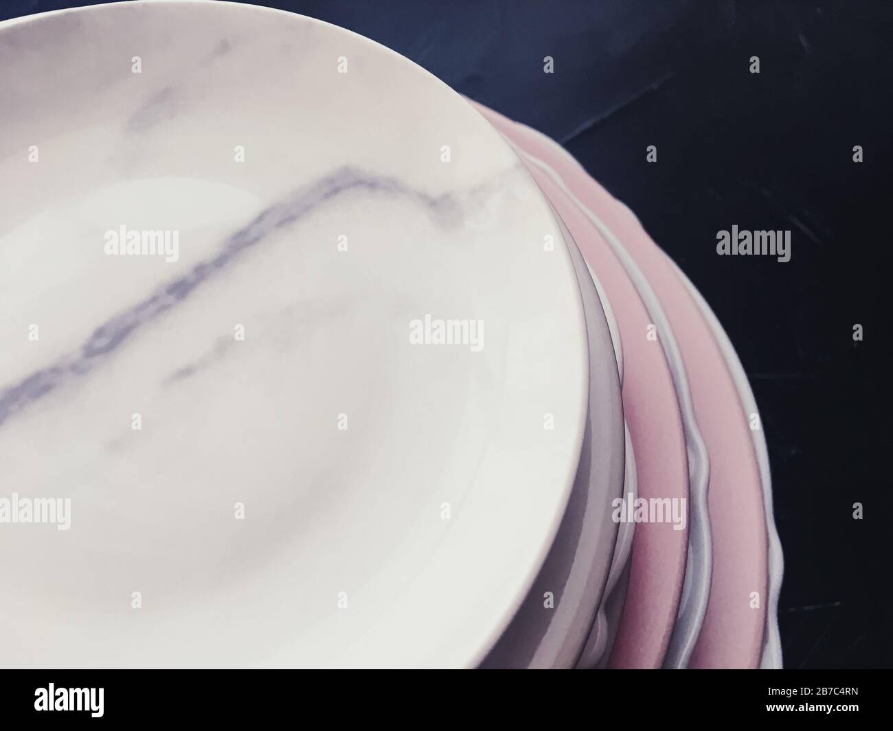 Stack of clean empty plates on black background, luxe dishware and ...