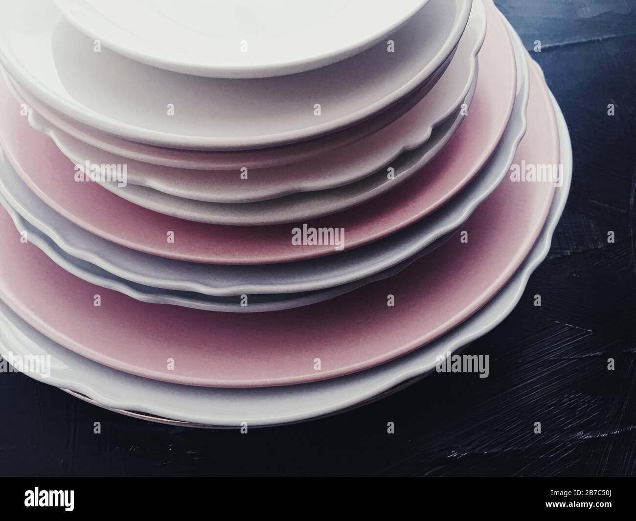 Stack of clean empty plates on black background, luxe dishware and ...