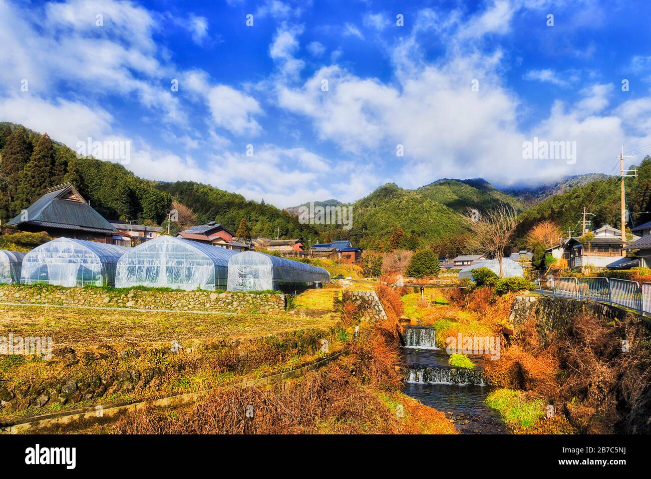 Small mountain stream of running water through agriculture village ...
