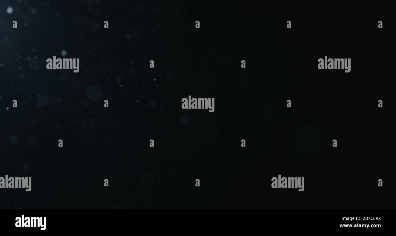 natural dust particles flow in air on black background, wide photo ...