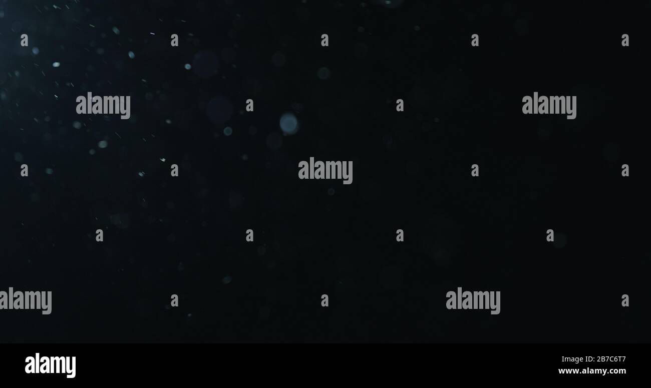 natural dust particles flow in air on black background, wide photo ...