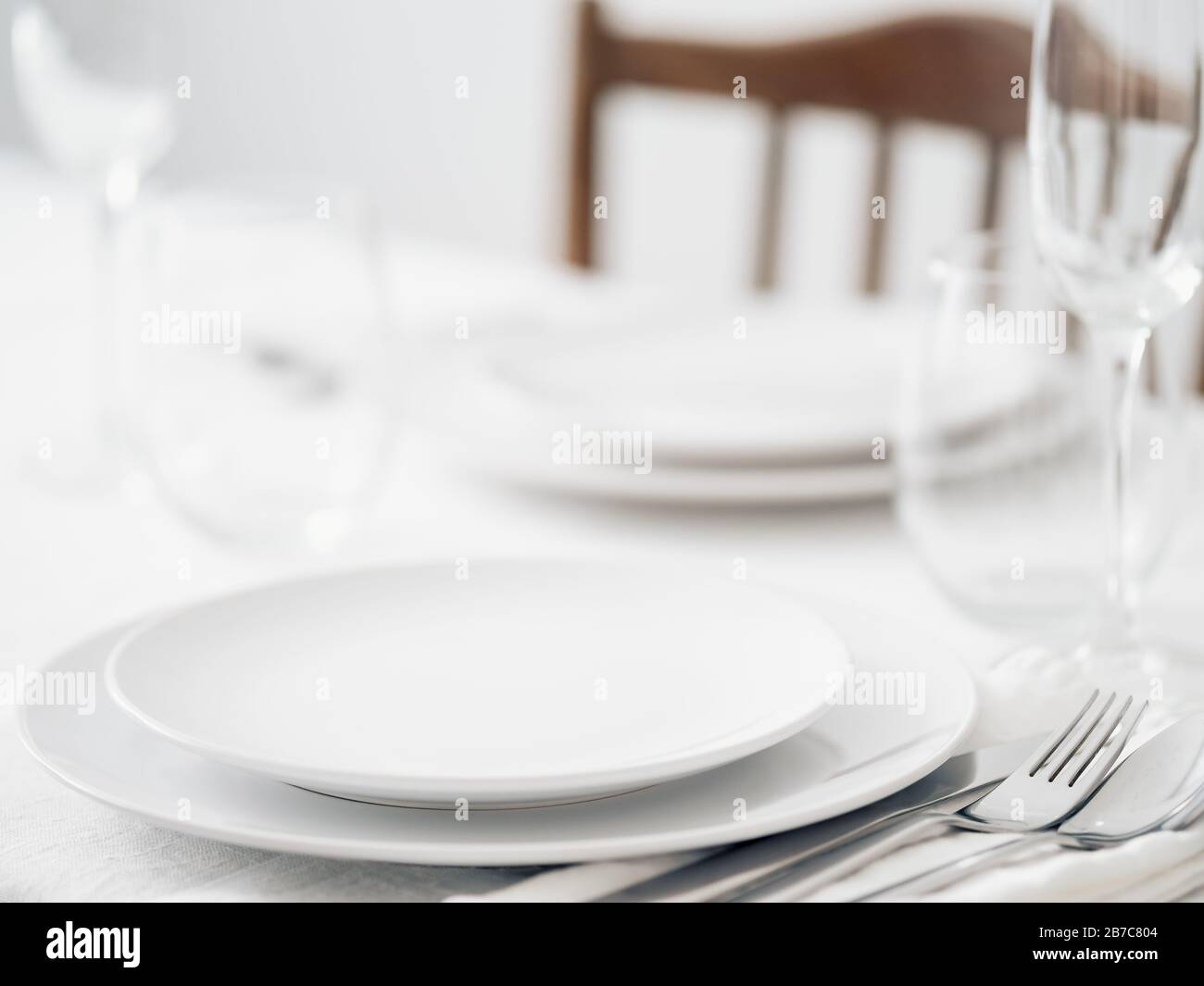Beautiful table setting in white colors. Empty white plates. Set table ...