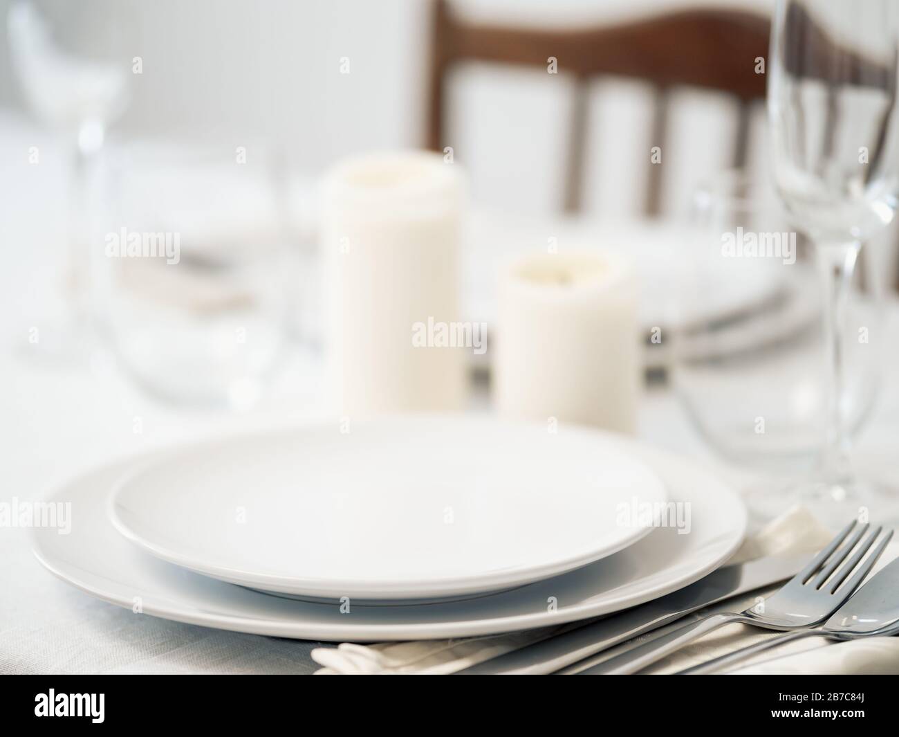 Beautiful table setting in white colors. Empty white plates. Set table ...