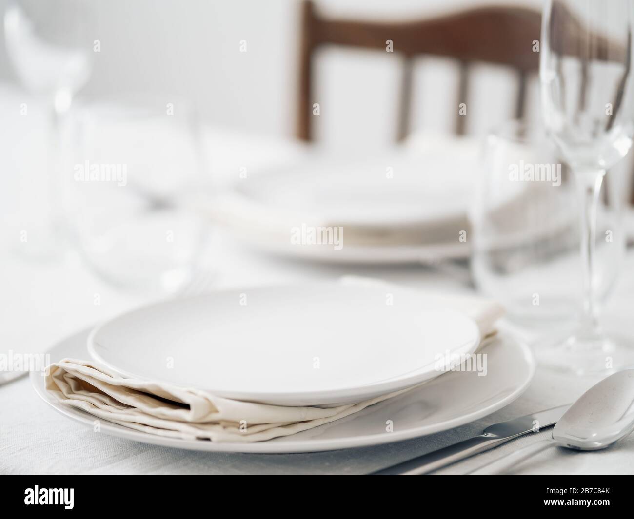 Beautiful table setting in white colors. Empty white plates. Set table ...