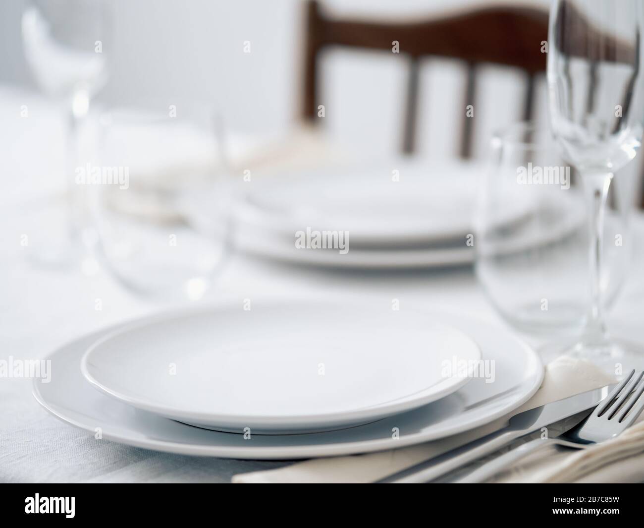 Beautiful table setting in white colors. Empty white plates. Set table ...