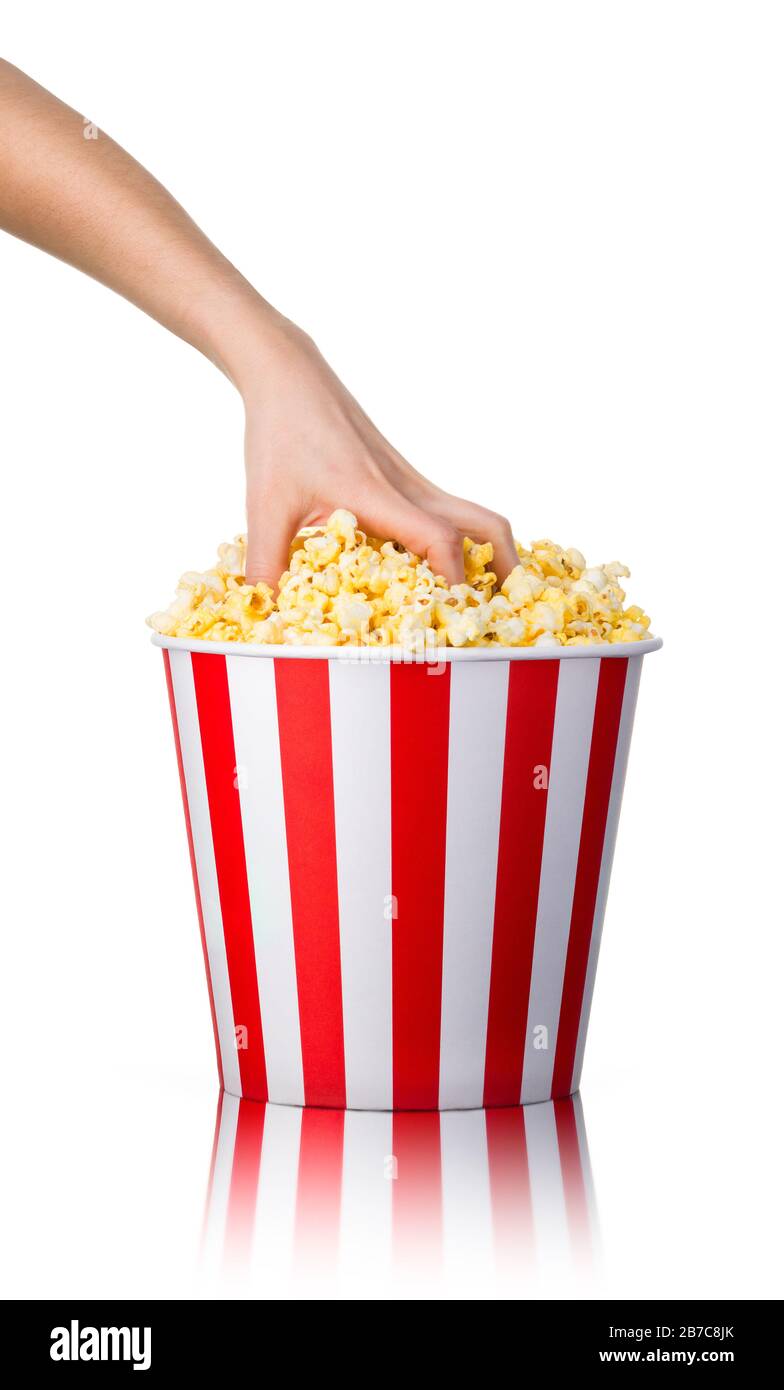 Woman hand picking popcorn from striped bucket isolated on white ...