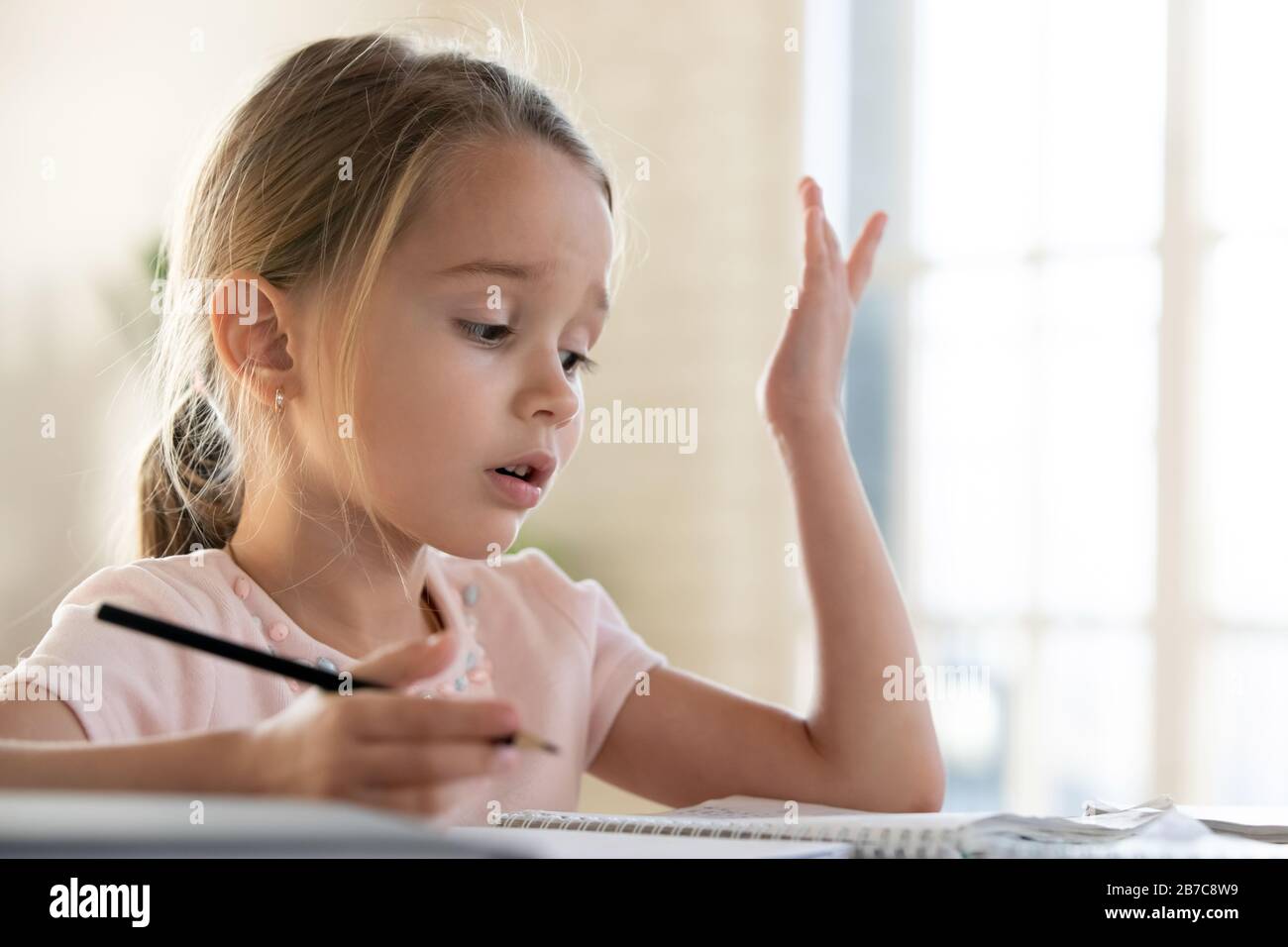 Small stressed girl stuck with hard homework Stock Photo - Alamy