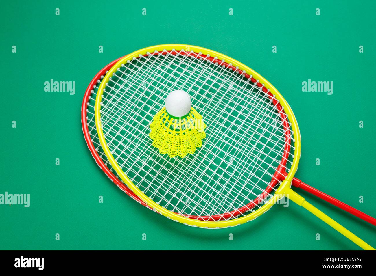 Two shuttlecock and badminton racket. on a green background. Concept ...