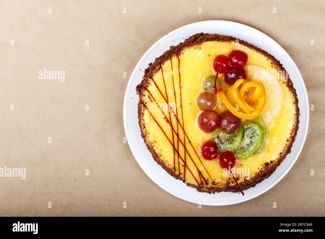 cake with cream and berries on craft paper, place for text. traditional ...