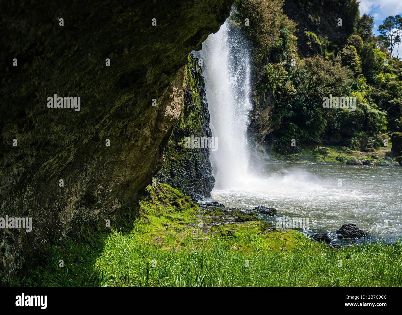 Beautiful scenery of a powerful waterfall flowing through a cliff into ...