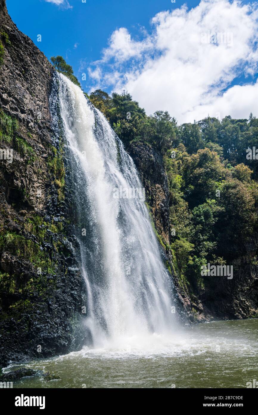 Beautiful scenery of a powerful waterfall flowing through a cliff into ...
