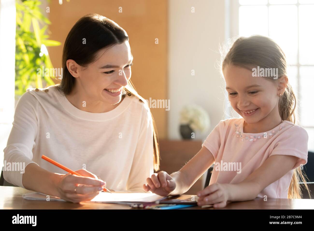 Young nanny tutor educating little preschool child girl Stock Photo - Alamy