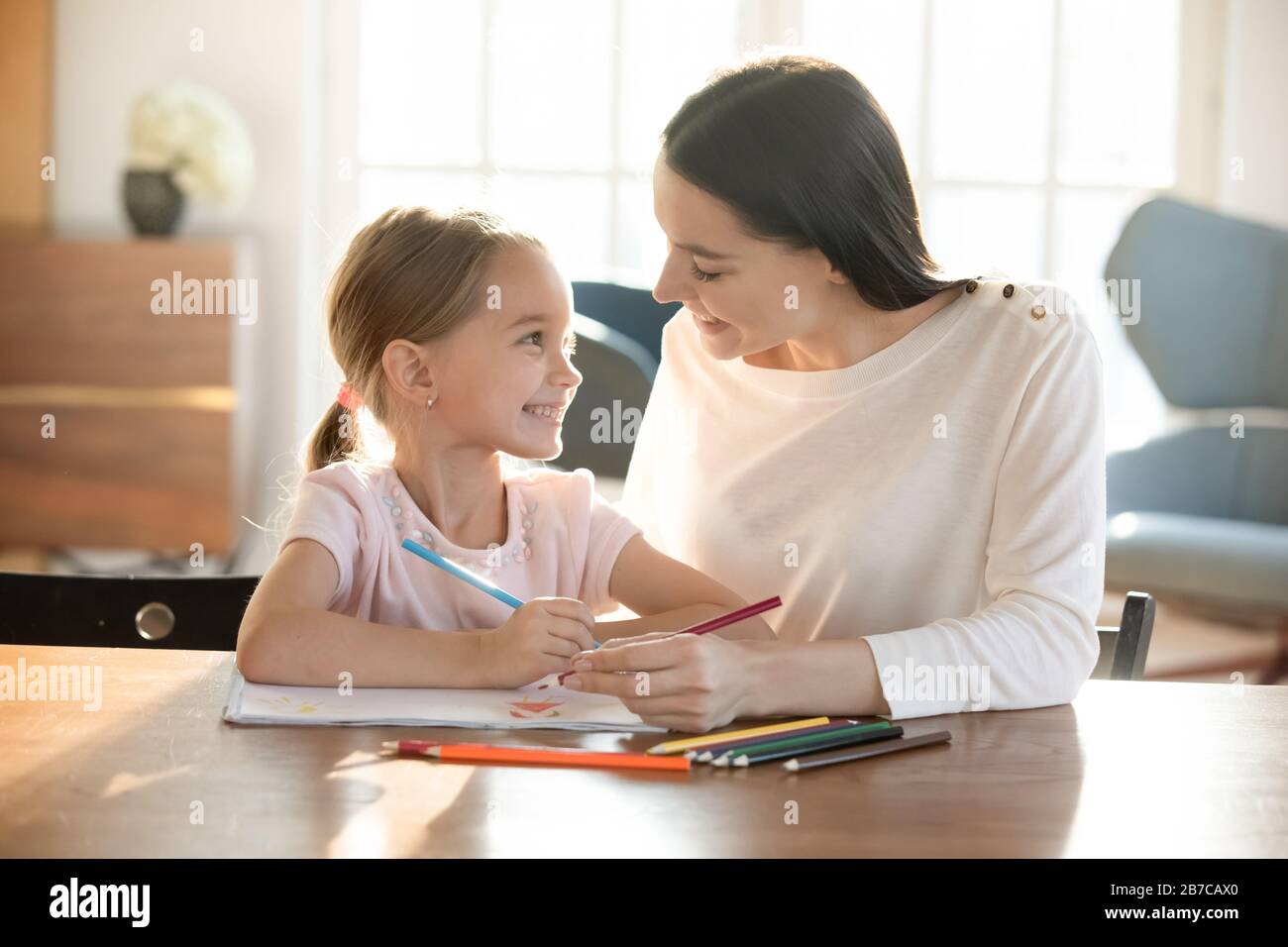 Smiling nanny developing drawing skills of little child girl Stock ...