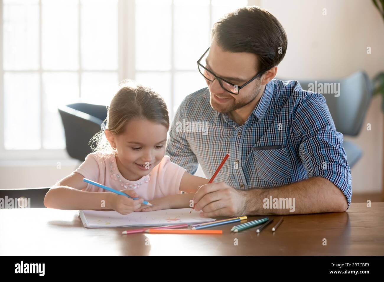 Young dad drawing pictures in paper album with small daughter Stock ...