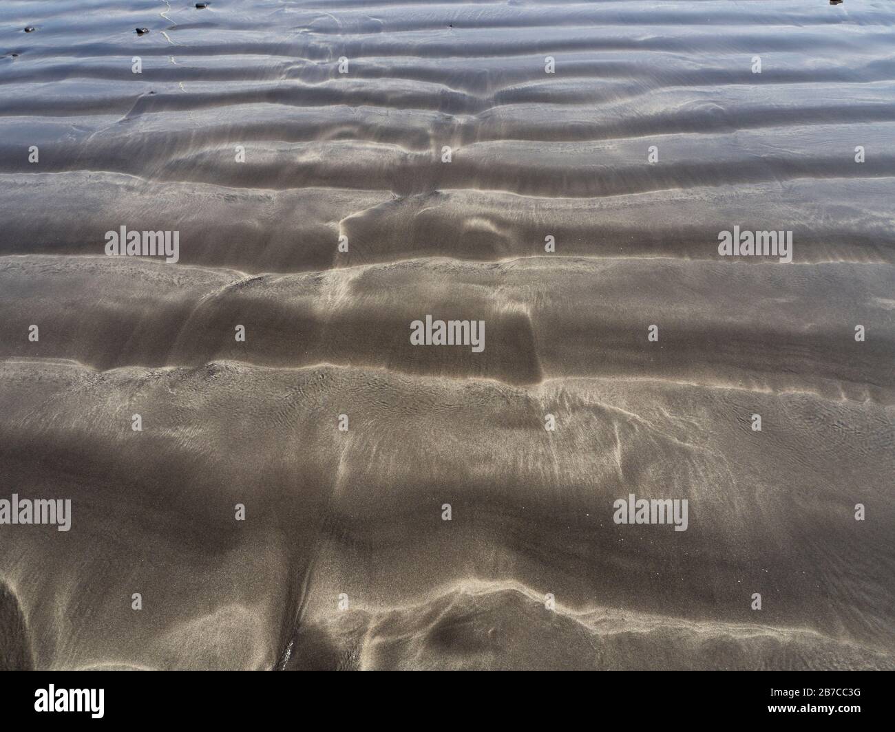 Wavy patterns of dark and golden sand on a beach in Tenerife, Canary ...