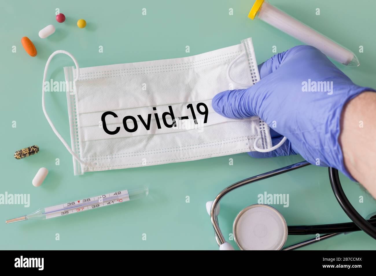hand in a medical glove grabbing a protective mask with the inscription ...