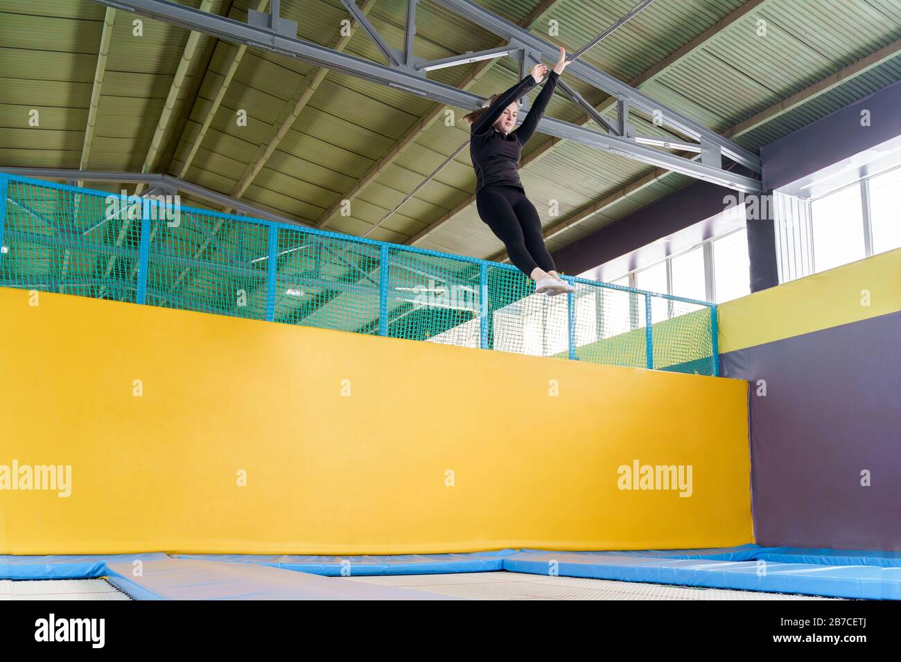 Young woman amateur acrobatic athlete jumping and exercising on a ...