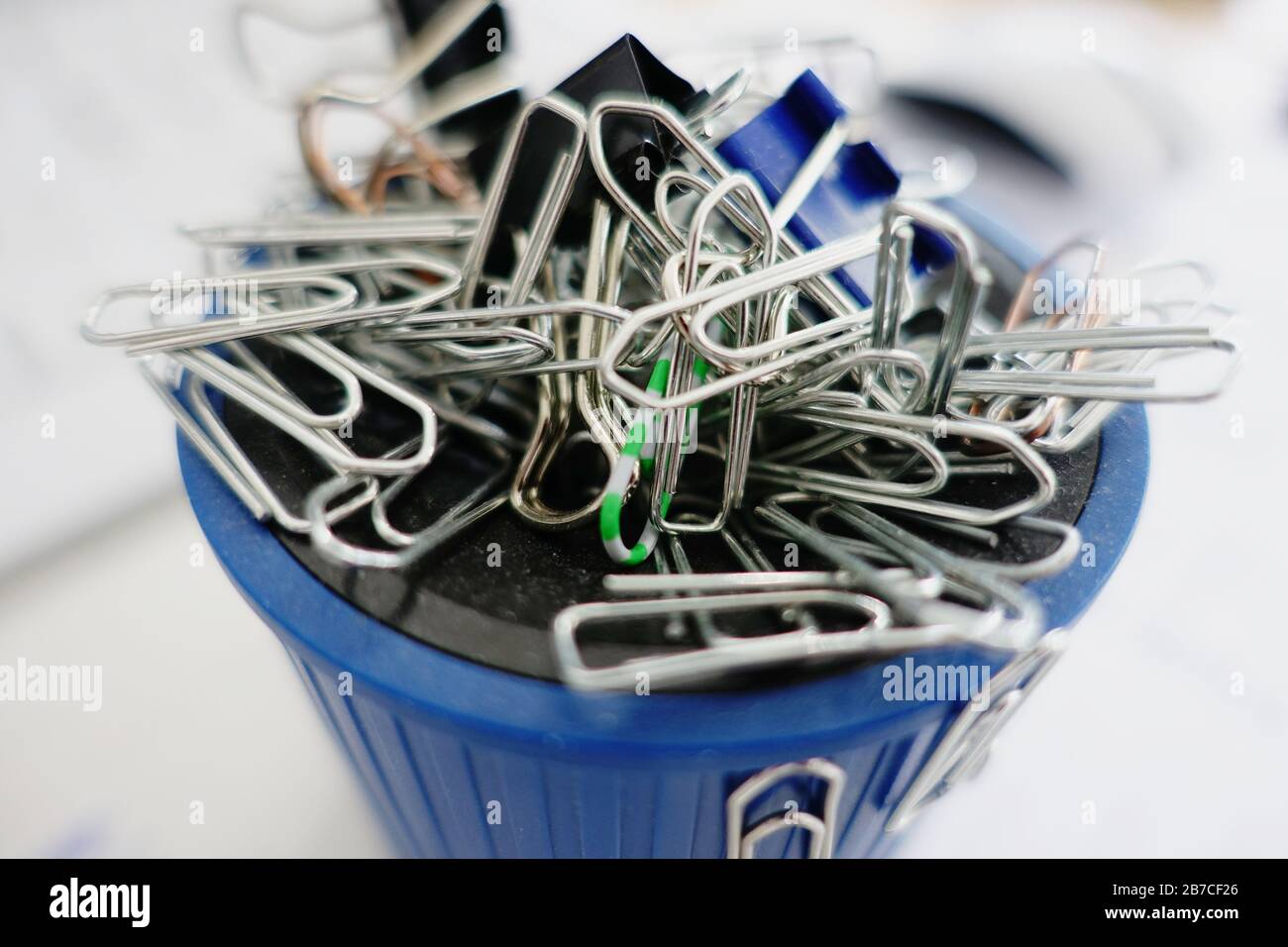 Close up photo of a bunch of paperclips on a blue magnetic paperclip ...