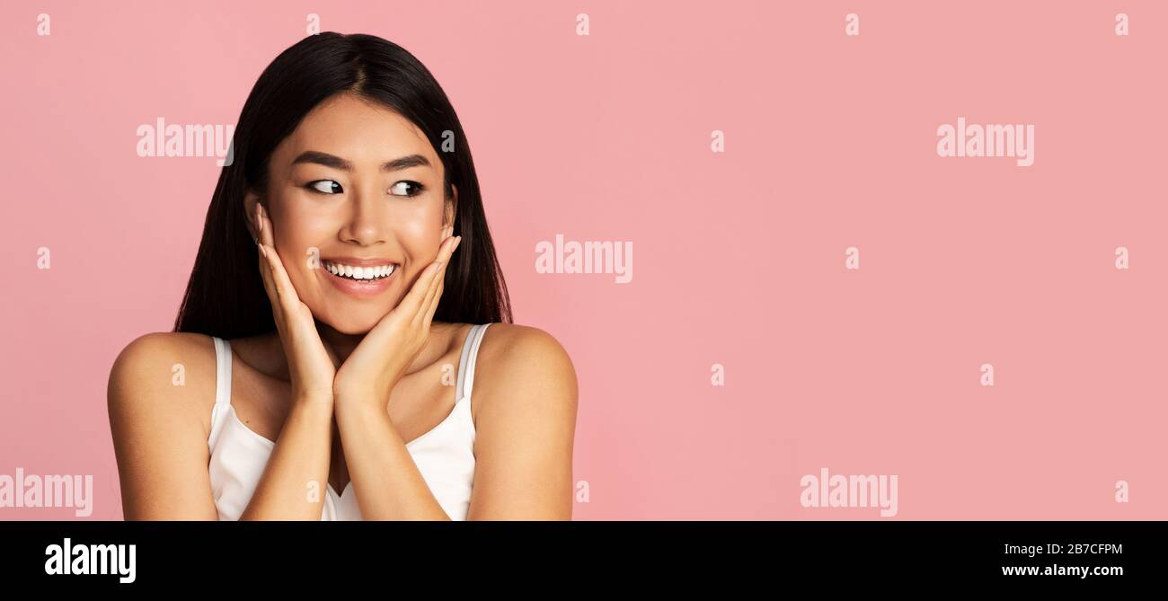 Happy Girl Cupping Face In Hands Looking Aside, Pink Background Stock ...