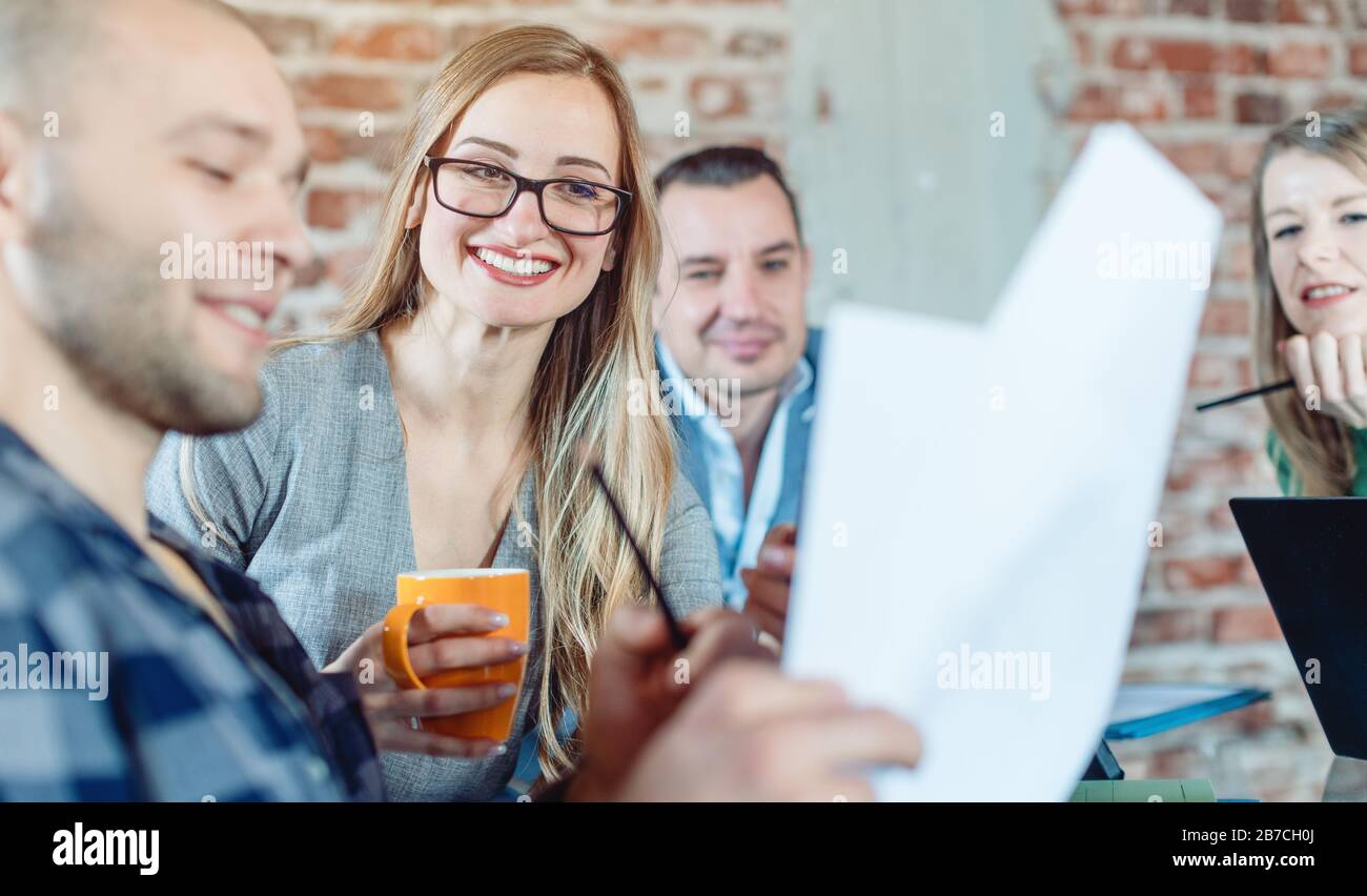Businesspeople in startup company looking at graphs and figures Stock ...