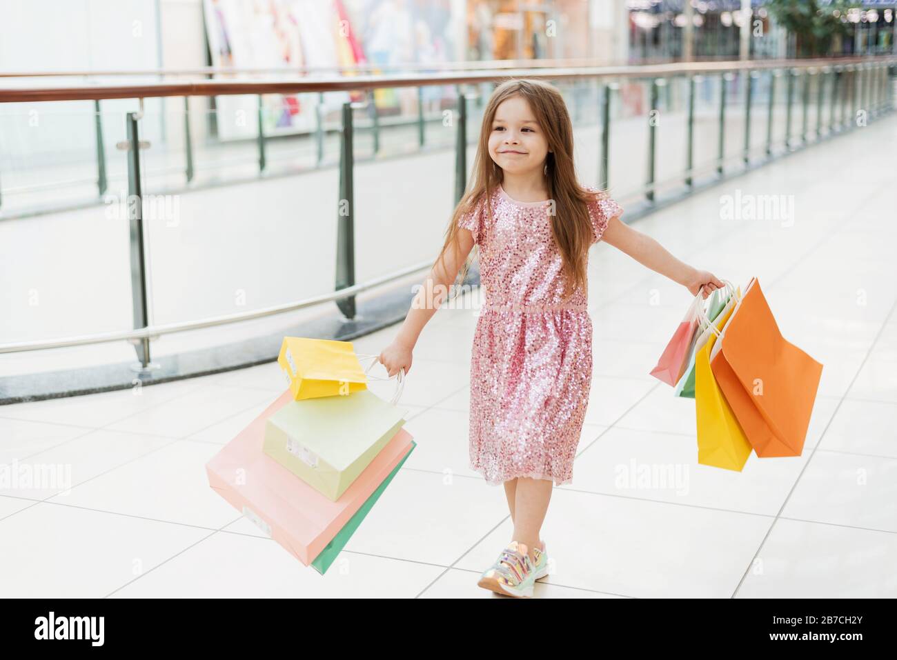 Portrait of a little happy girl in the mall. A smiling laughing girl in ...