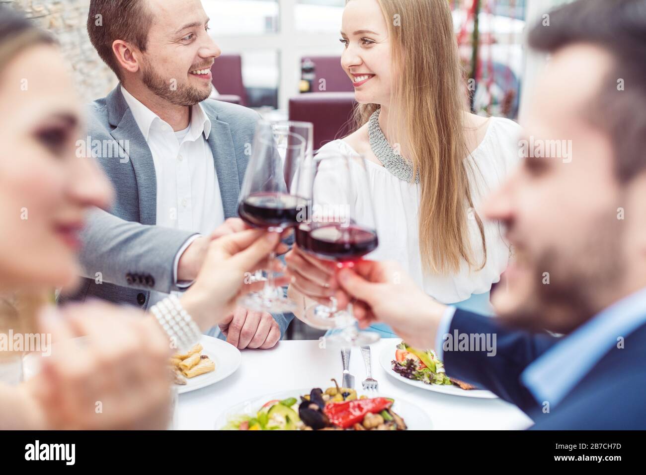 Cheerful people enjoying drink and food in Italian restaurant Stock ...