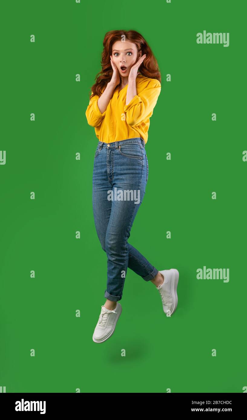 Shocked Girl Jumping Cupping Face In Hands Over Green Background Stock ...