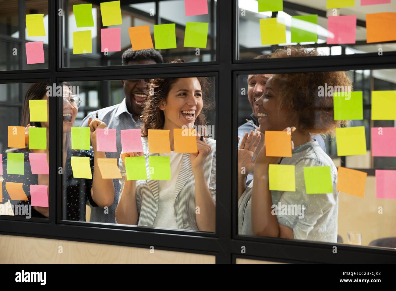 Excited diverse employees celebrating success at scrum meeting Stock ...