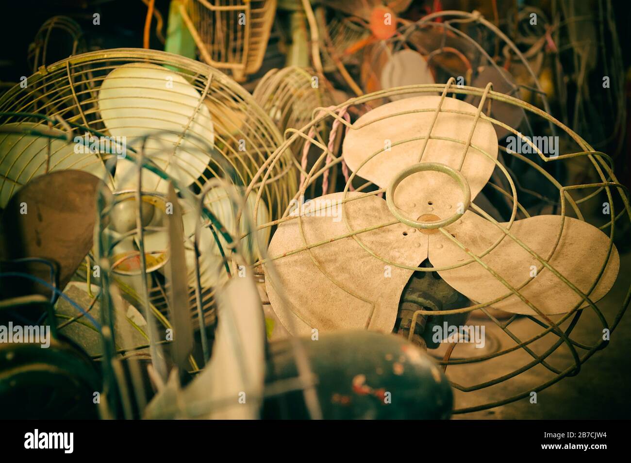 Collection of ancient, broken fans laying on floor in chaotic way Stock ...