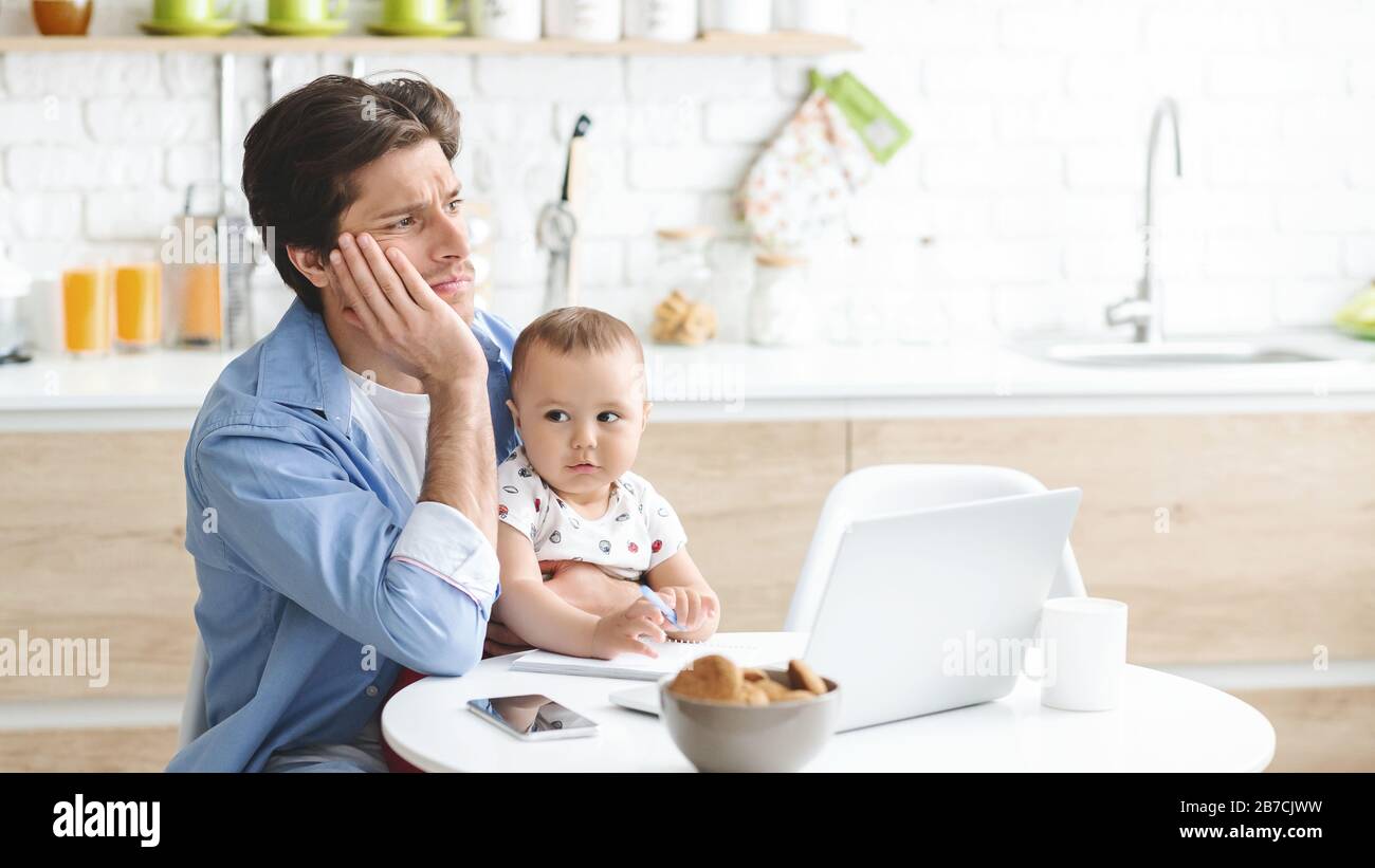 Tired dad working with baby son at home kitchen Stock Photo - Alamy