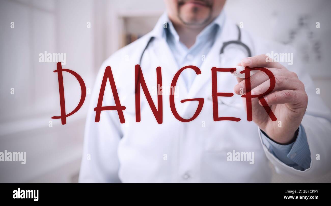 Doctor writing word DANGER on virtual screen in hospital, closeup Stock ...