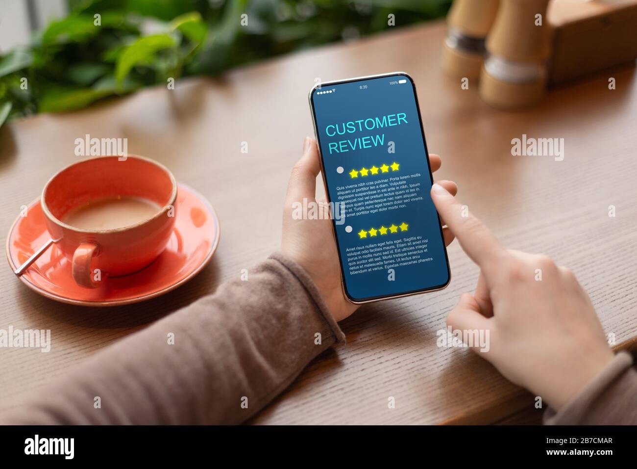 Girl holding cell phone with customer review text on screen Stock Photo ...