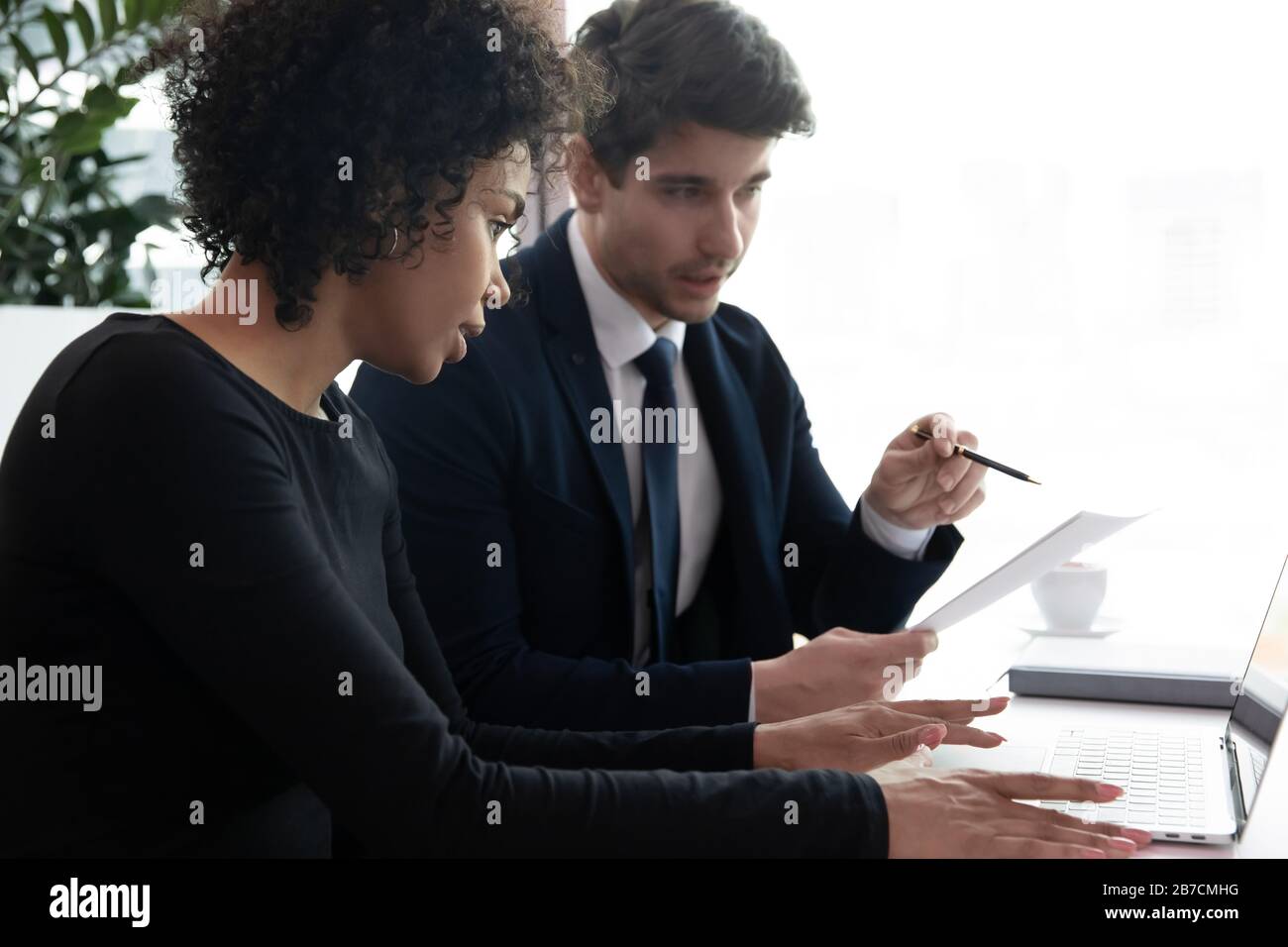 Multiracial colleagues brainstorm using laptop in office Stock Photo - Alamy