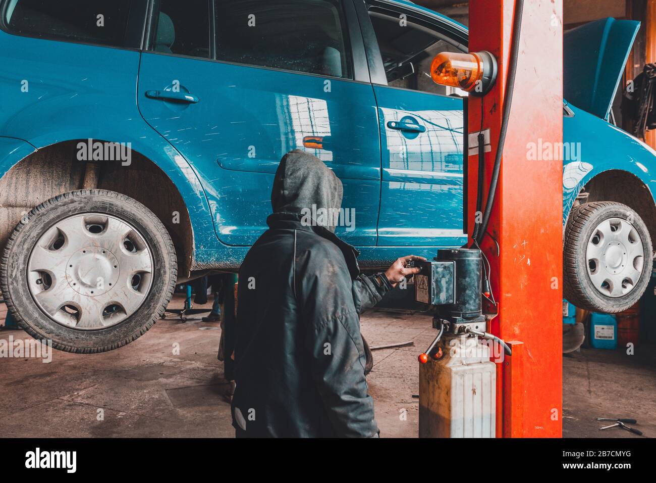 The mechanic lifted the car with a lift to service the engine 2020 ...