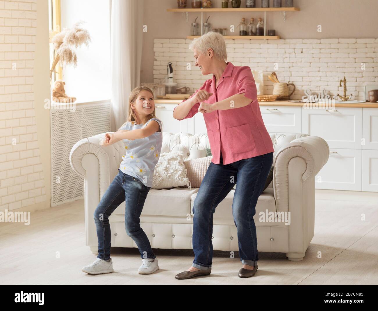 Cheerful older lady with her granddaughter dancing at home Stock Photo ...