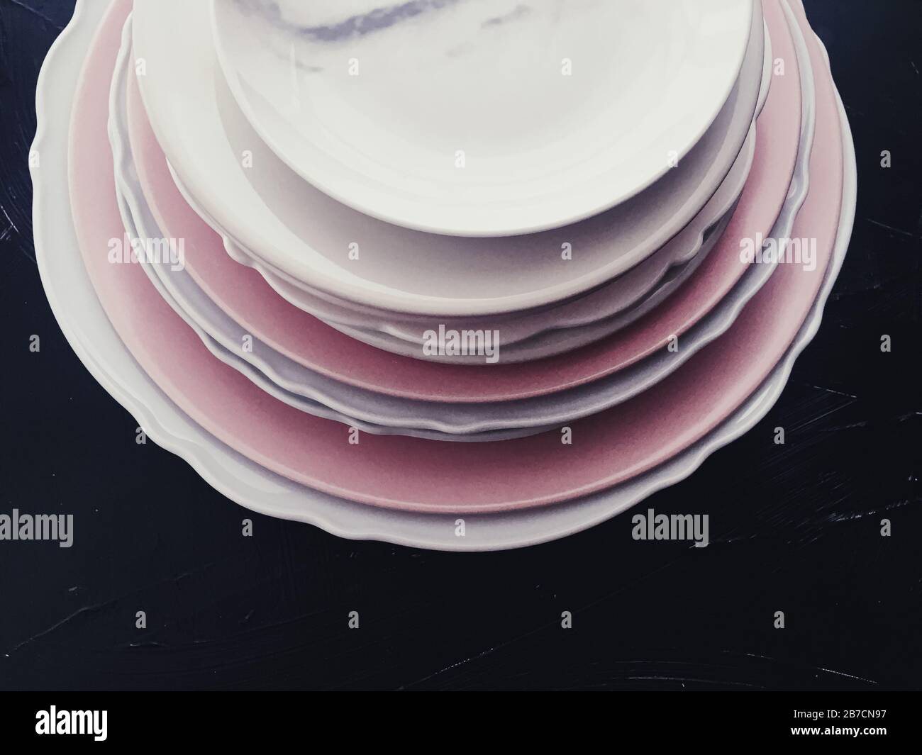 Stack of clean empty plates on black background, luxe dishware and ...