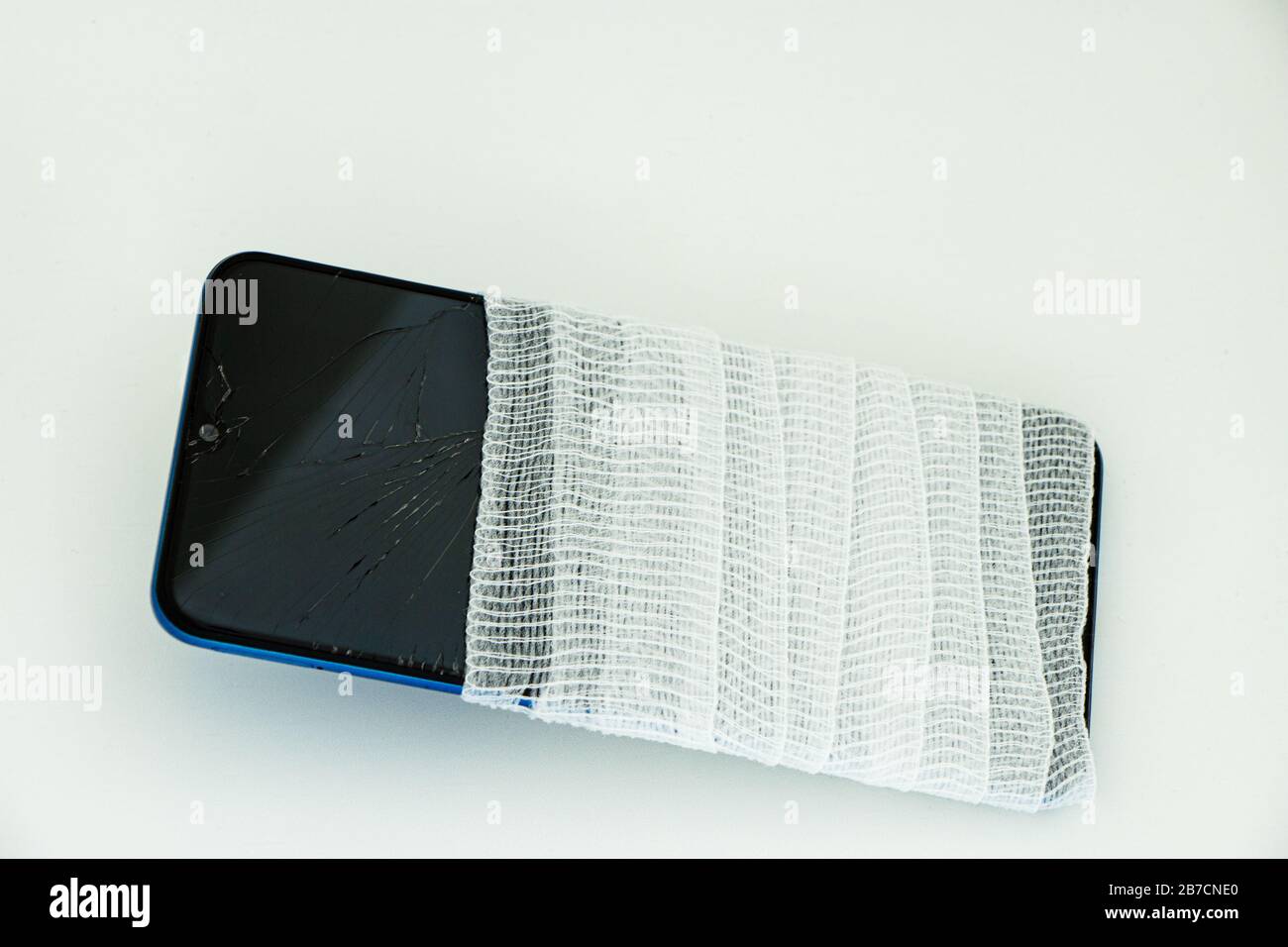 Concept of a broken smartphone in bandage with a white backdrop, cracks ...