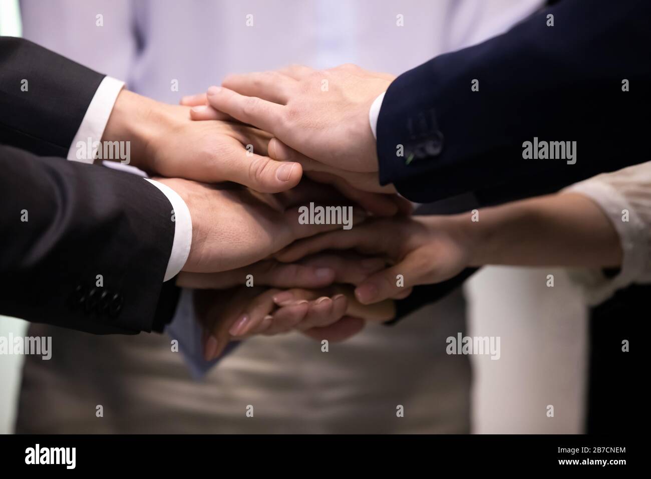 Diverse colleagues stack hands showing support at work Stock Photo - Alamy