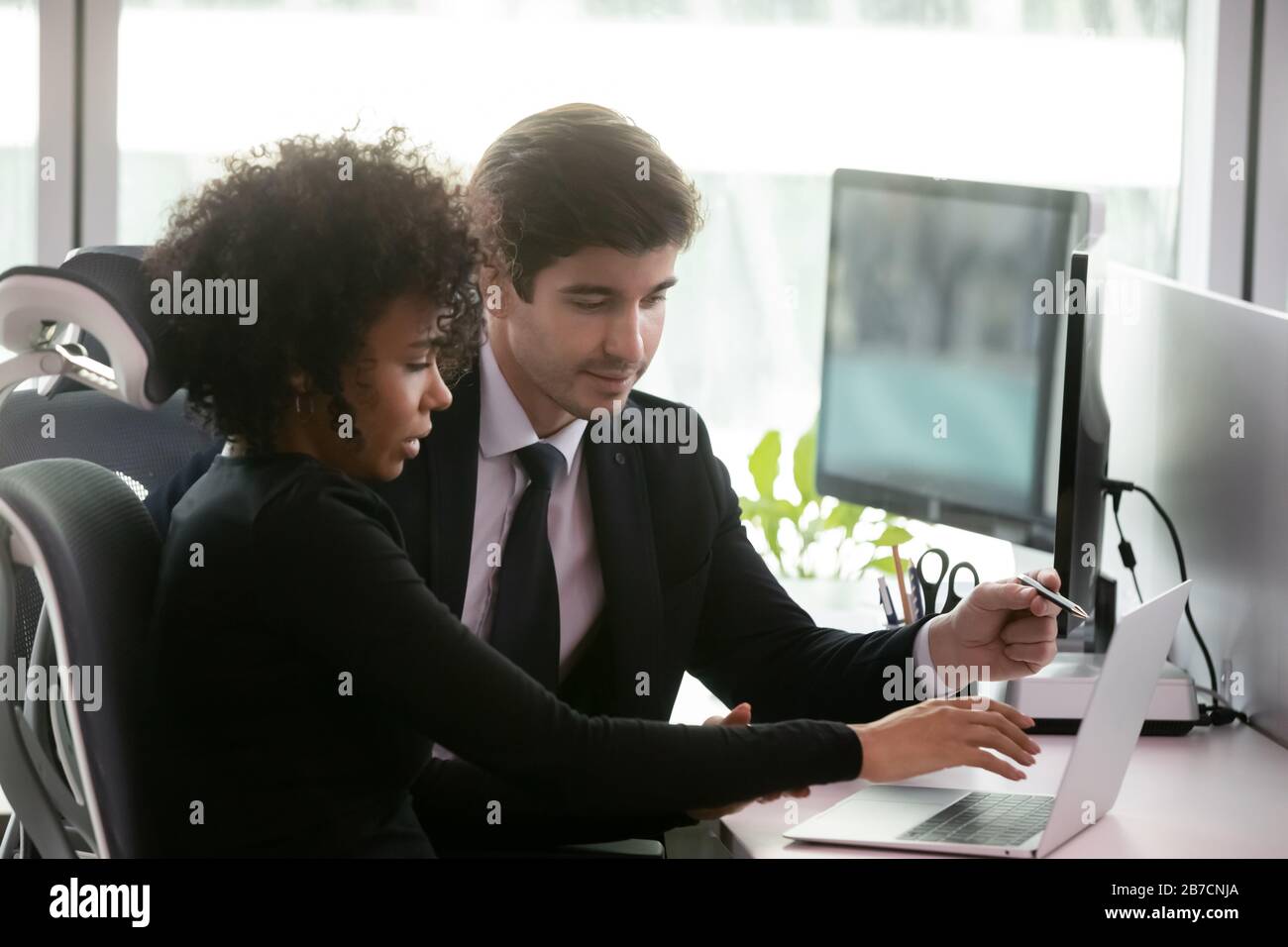 Focused businesspeople brainstorm working on laptop in office Stock ...