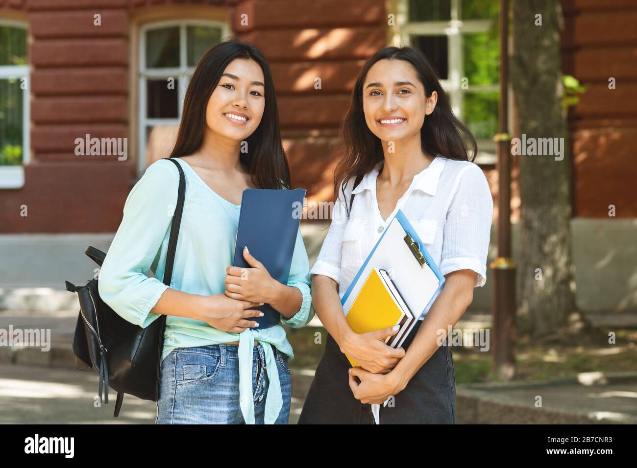 Happy university classmates having break in college campus, posing ...