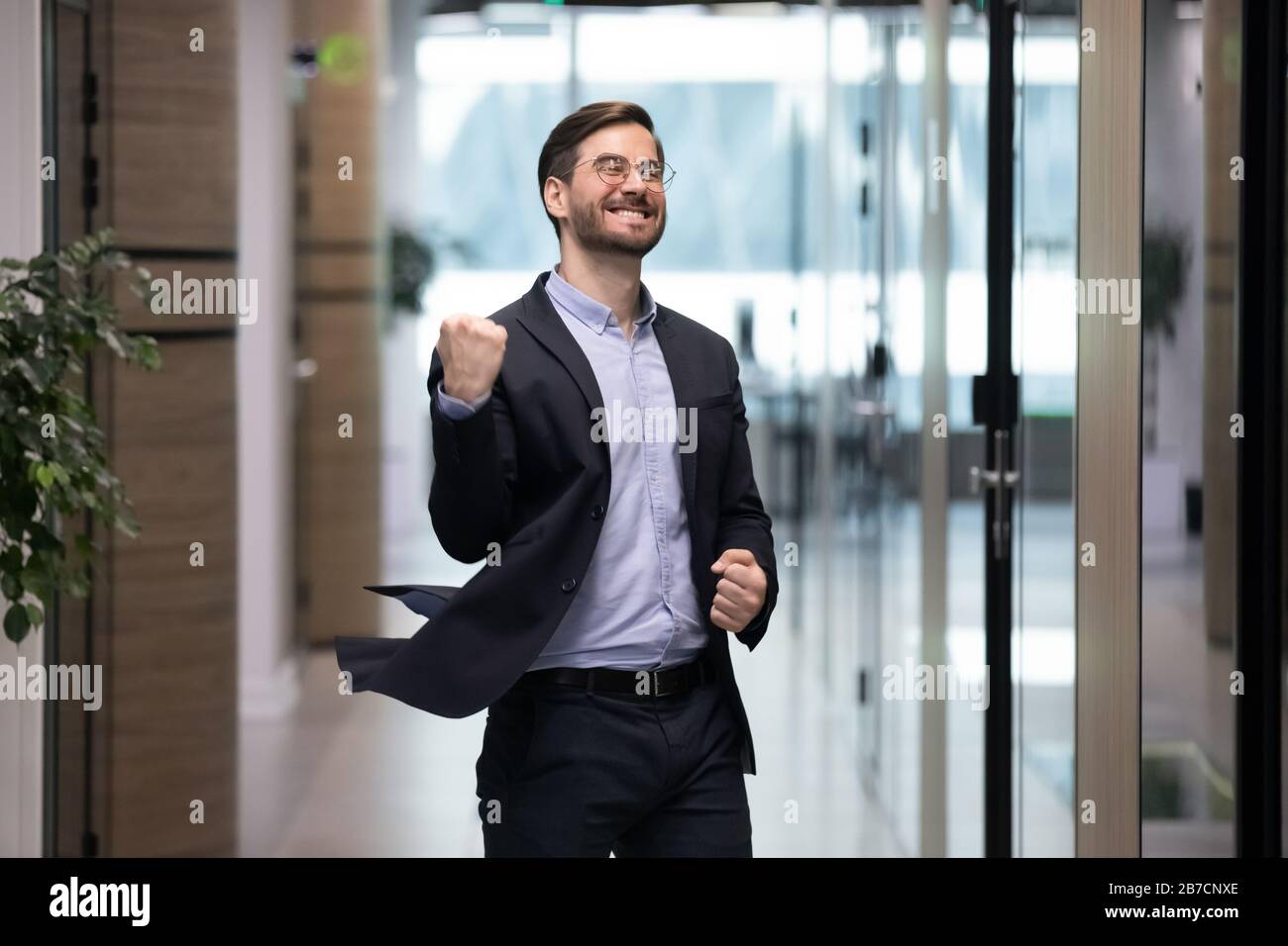 Happy young employee dancing in office celebrating success Stock Photo ...