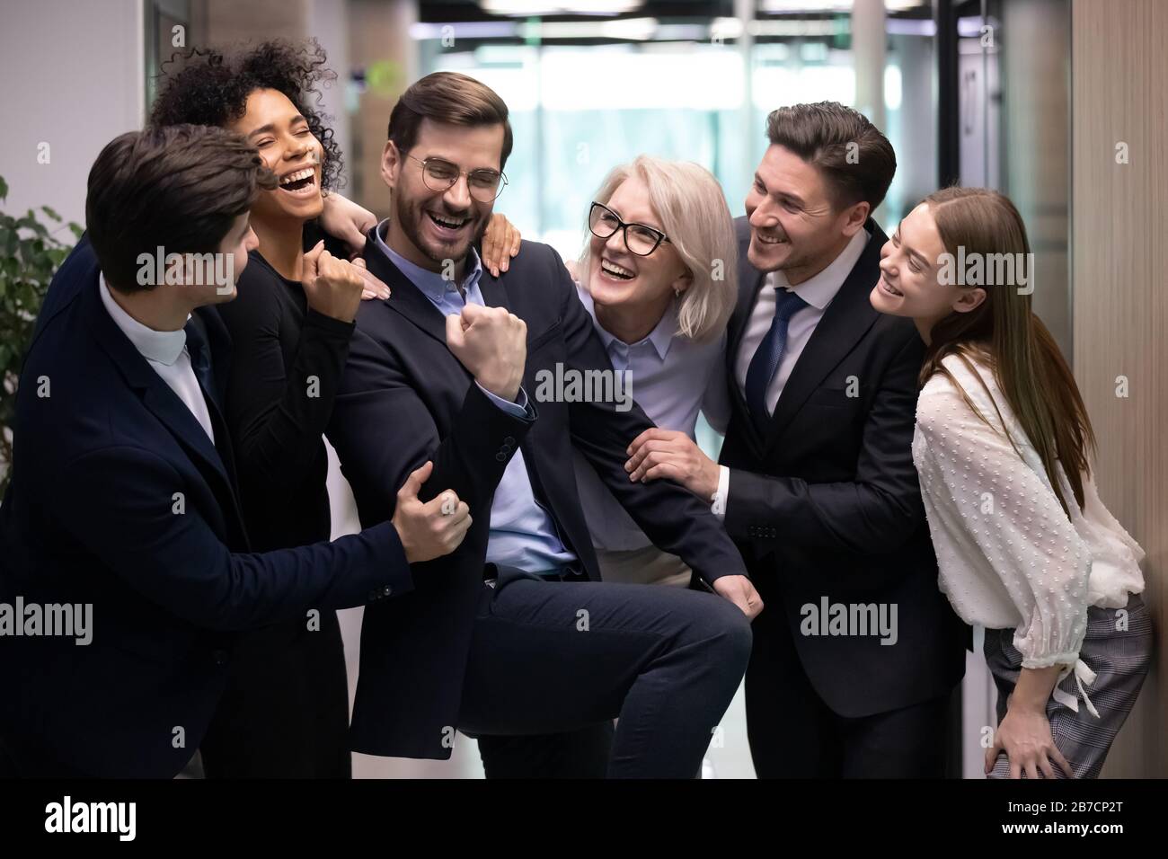 Excited diverse colleagues celebrate shared business win together Stock Photo - Alamy