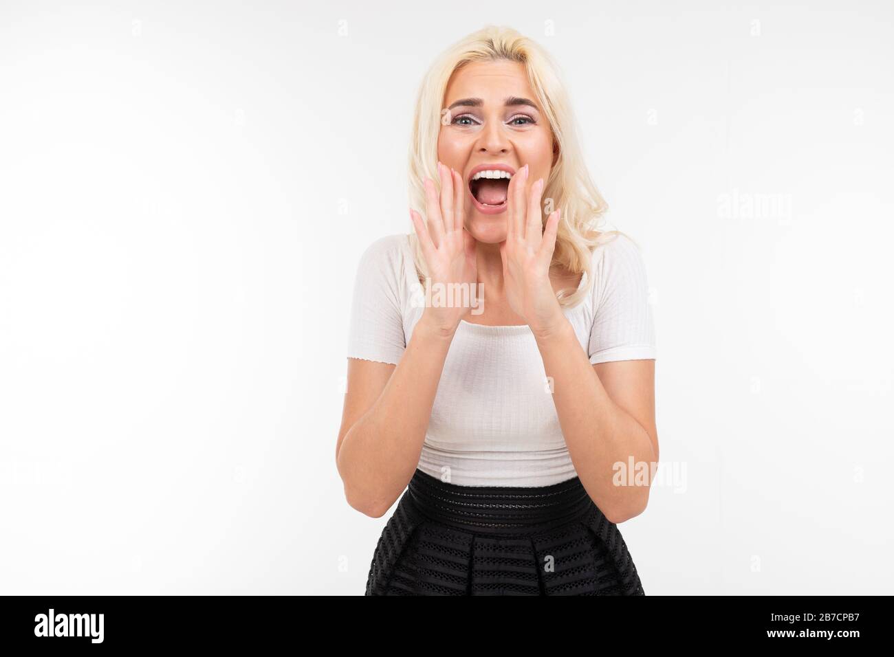 blond girl shouting news on a white studio background with copy space ...