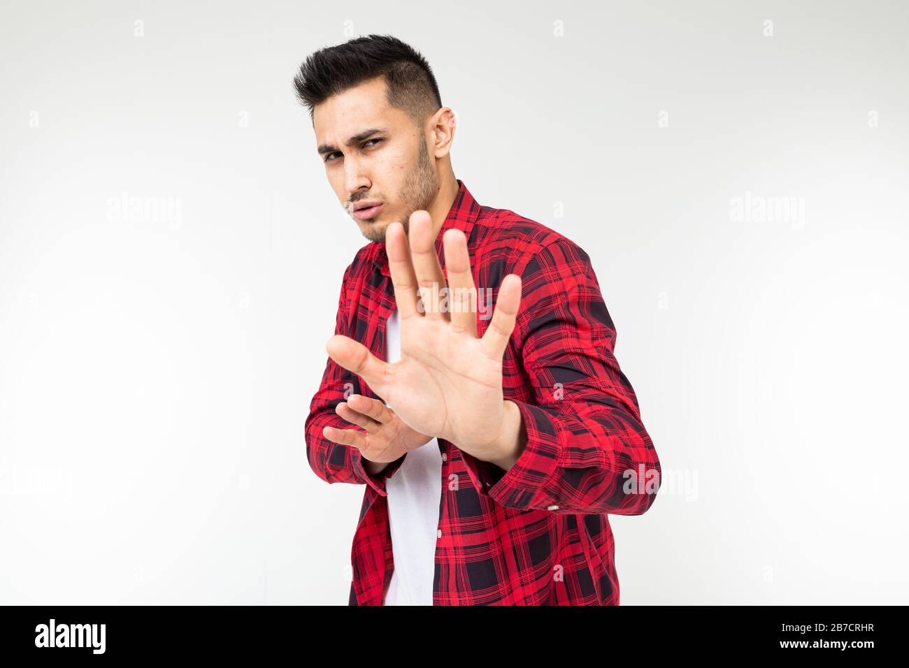 brunette guy in a checkered shirt swinging open hand wave on a white ...