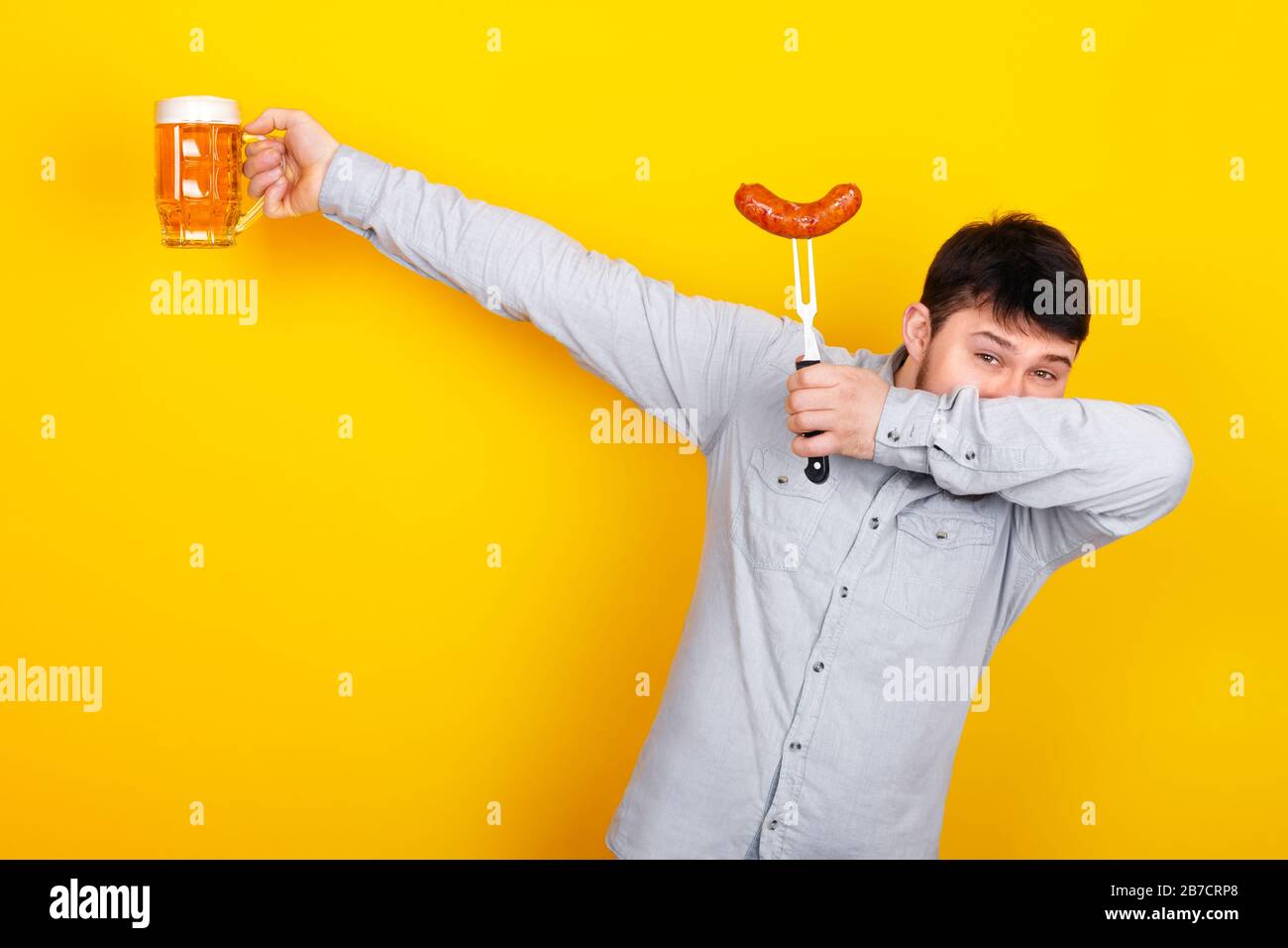 trendy alcoholic with beer standing in dab dance pose over yellow ...