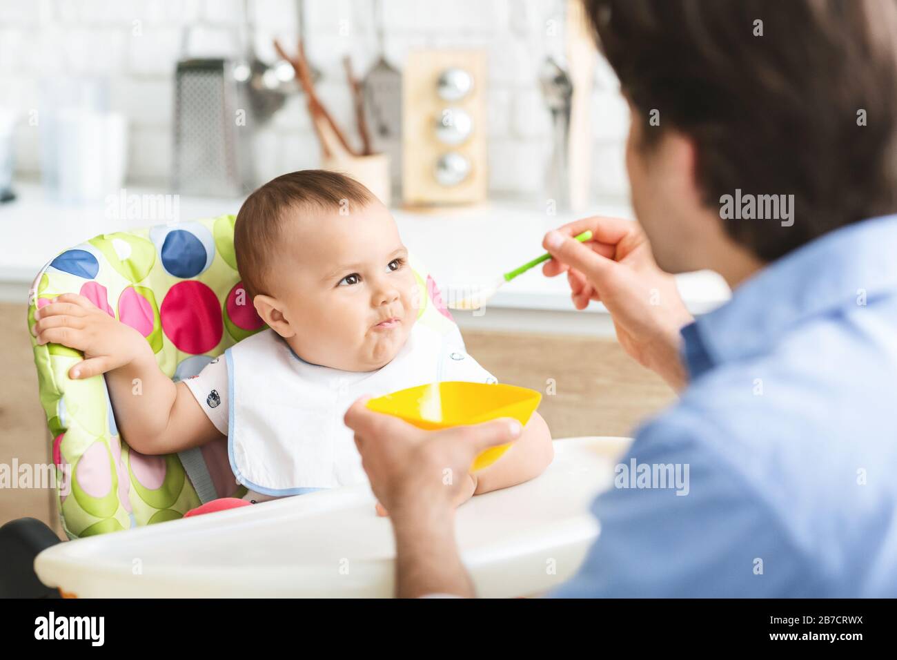 Hungry baby eating healthy kid food in kitchen Stock Photo - Alamy